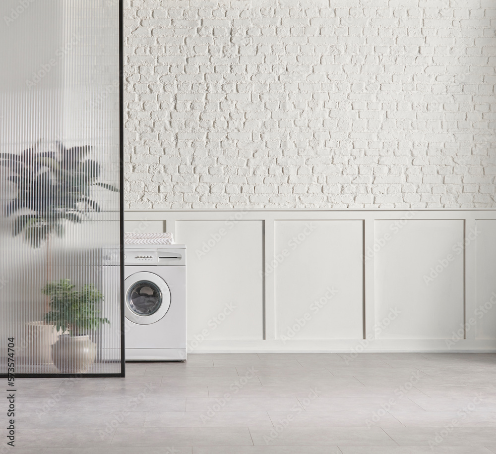 Washing machine in the bathroom, white brick wall background, vase of ...