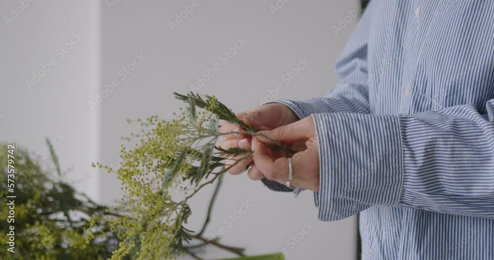 woman's hands cut off excess from flowers. Girl working in flower shop ...