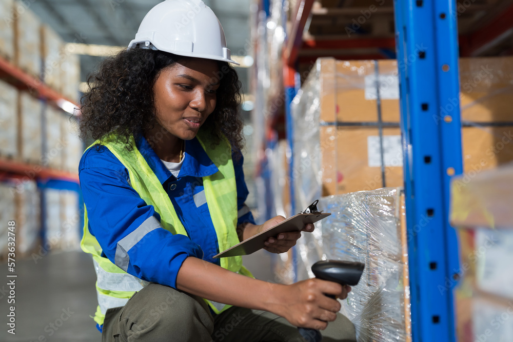 African American female warehouse worker scanning barcodes on boxes on ...