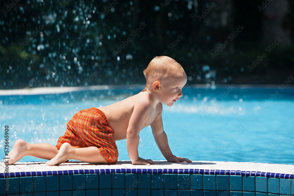 Funny photo of active baby splashing in swimming pool with fun, jump ...