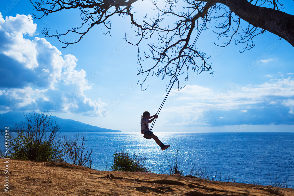 Foto de Happy girl have fun swinging high in mid air. Flying up upside ...