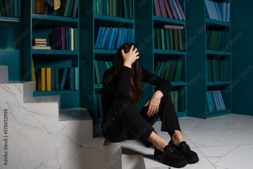 Foto de A sad student is sitting on a strange staircase against the ...