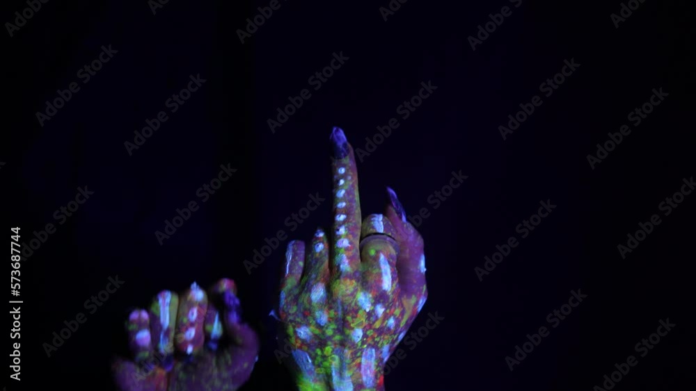 A hand with a fluorescent ethnic pattern shows the middle finger ...