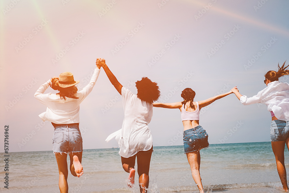 Four happy friends at sunset beach party runs to water, Silhouette ...