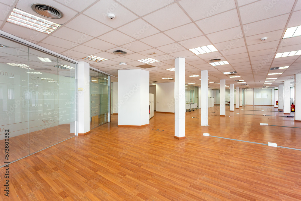 Large empty space with ceiling tiles, fluorescent lights, light brown ...