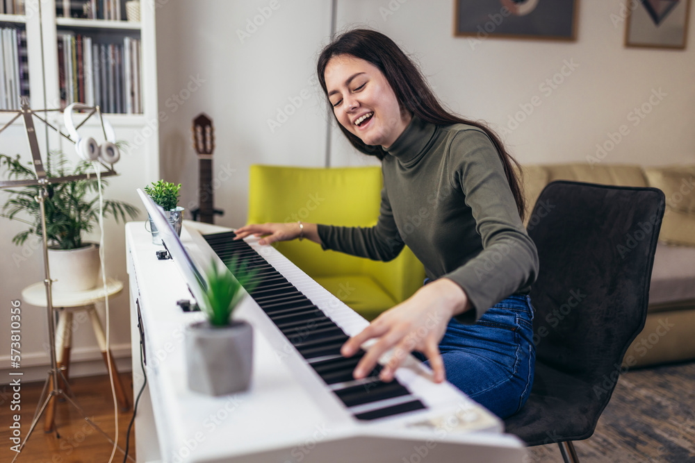 Happy girl is playing piano for her hobby relax time in home living ...