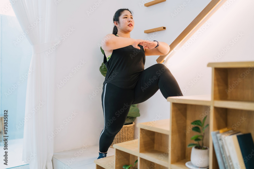 chubby woman doing stairs exercise indoors living room split squats ...