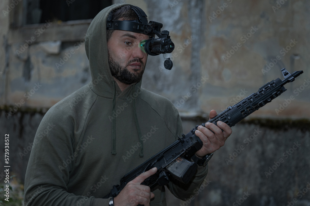 Civilian man with a gun and a night vision device in a war at night ...