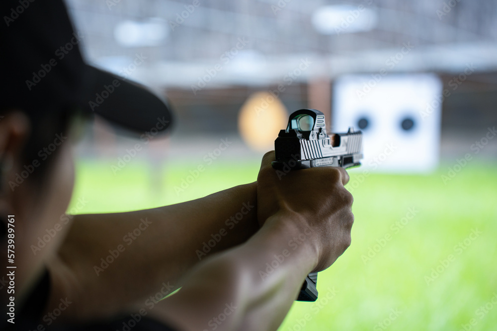 Selective focus of hands of an Asian man wearing a cap, holding a black ...