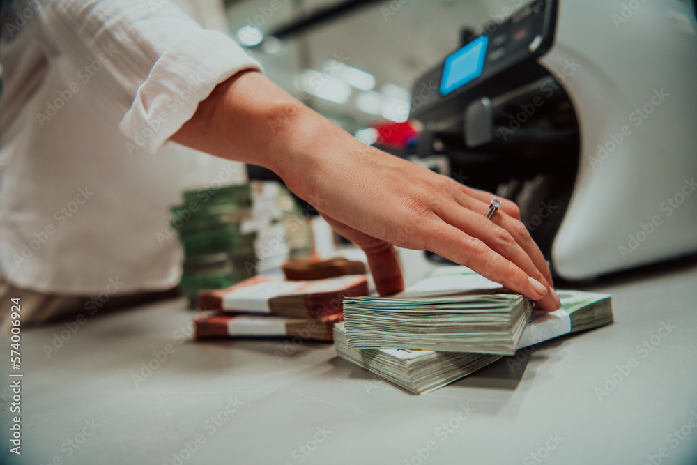 Bank employees using money counting machine while sorting and counting ...