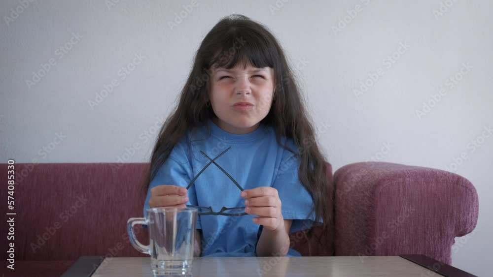 Child feels eye strain tension. A little girl use glasses because of ...