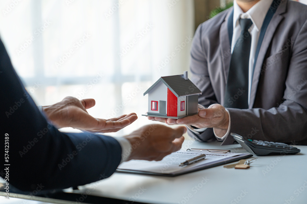 Young Asian real estate agent, and insurance salesman handing over a ...
