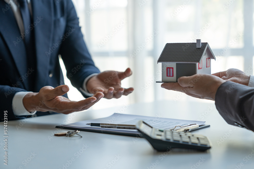Young Asian real estate agent, and insurance salesman handing over a ...