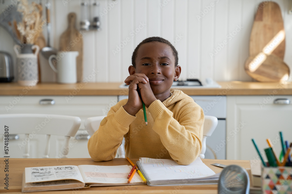 Happy Black schoolboy learning at home with textbook. Smiling African ...