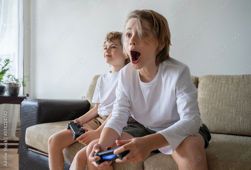 Excited children passionately playing video games controller console ...