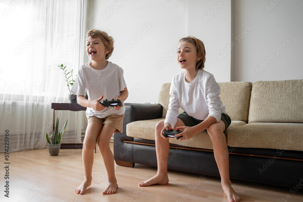 Funny caucasian siblings passionately playing video games in front of ...