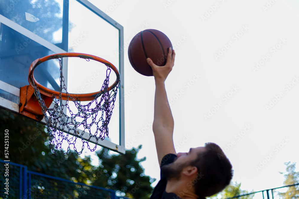 Fotka „handsome basketball player shooting a ball through the hoop ...