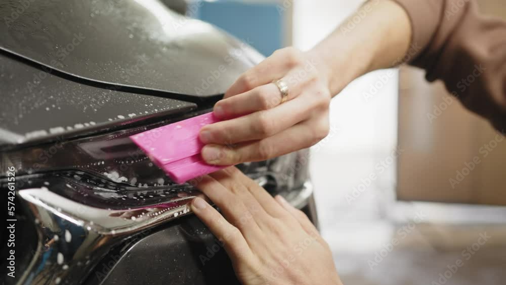 Close up to PPF installation process on a front headlight . PPF is a ...