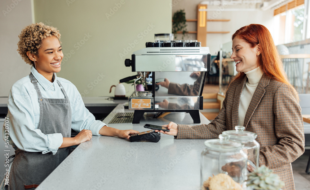 Happy client paying by mobile phone in a coffee shop. Side view of a ...