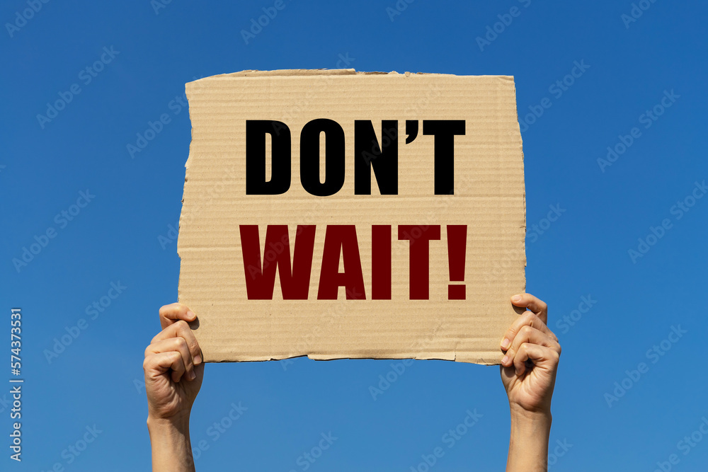 Don't wait text on box paper held by 2 hands with isolated blue sky ...