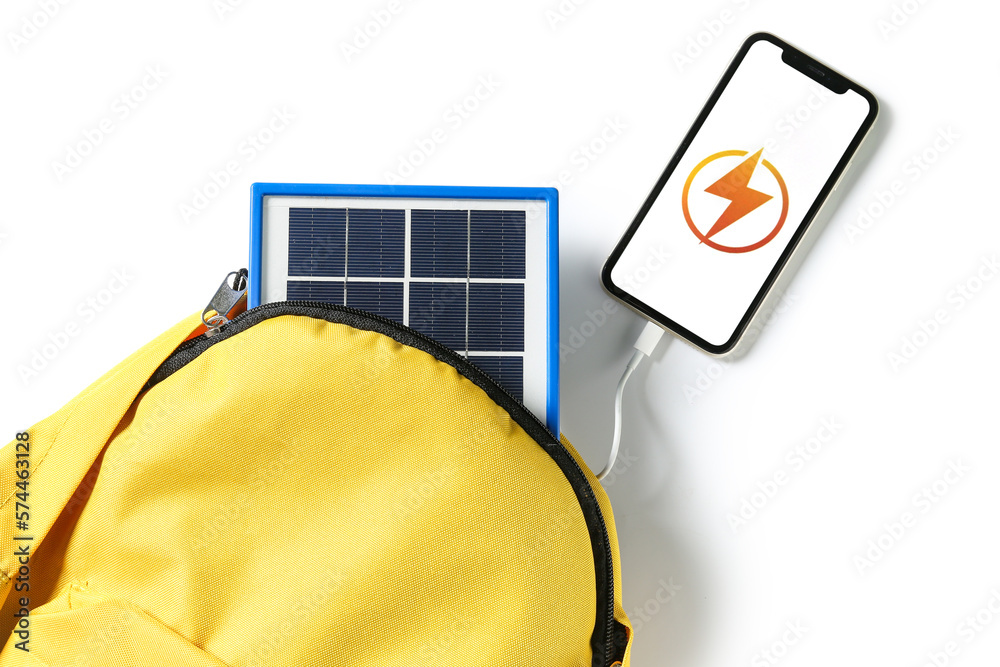 Backpack with portable solar panel charging mobile phone on white ...