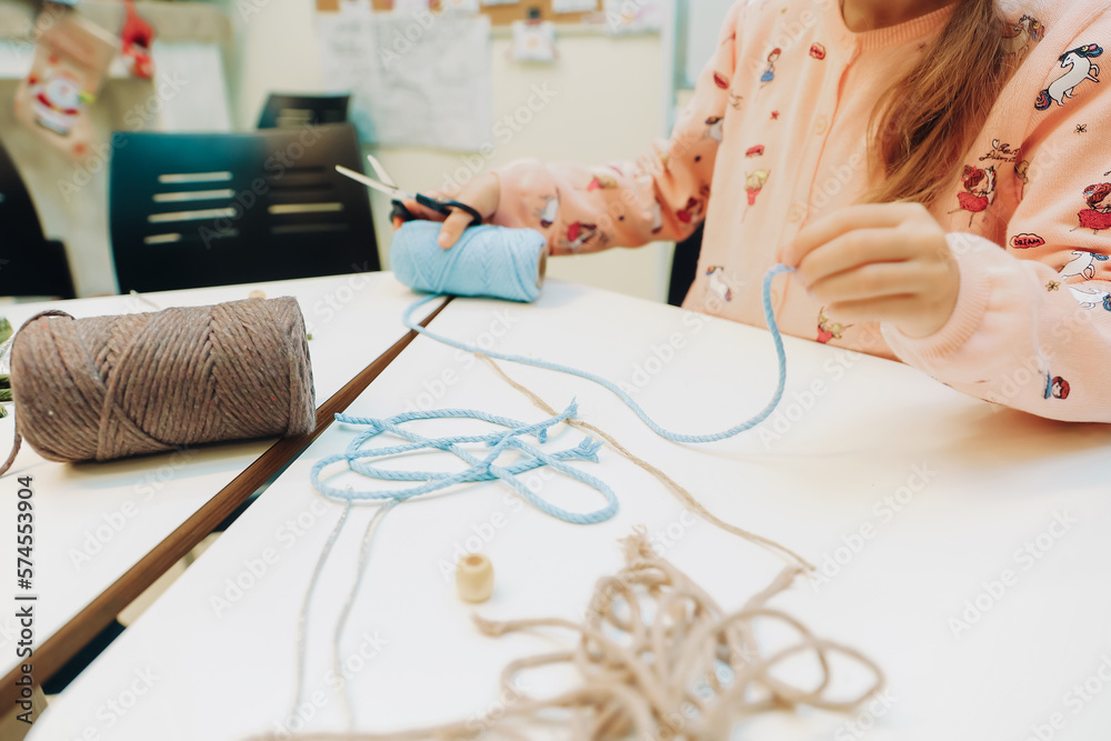 Child makes braids of wool. Making home decorations. Easy fun kids ...