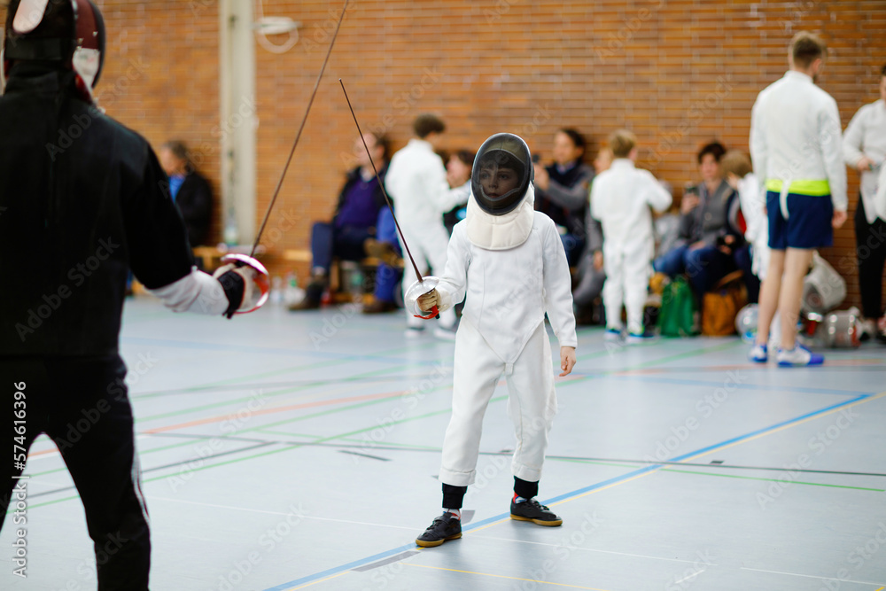 Little kid boy fencing on a fence competition. Child in white fencer ...