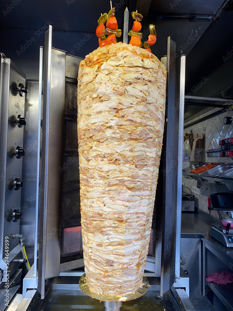 Grilled chicken meat on a vertical rotisserie used in traditional ...