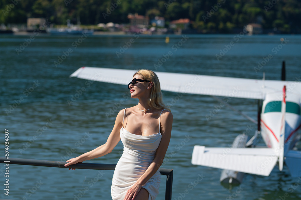 Beautiful model walks away from her private jet on holiday. Business woman near private jet ...