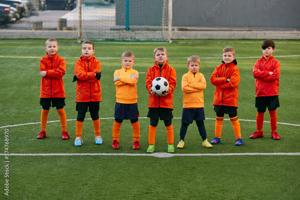 Group of boys, children, football players in uniform standing in a line ...