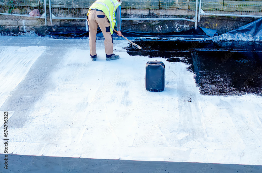 Waterproofing coating. Builder applying waterproofing bitumen mastic on ...