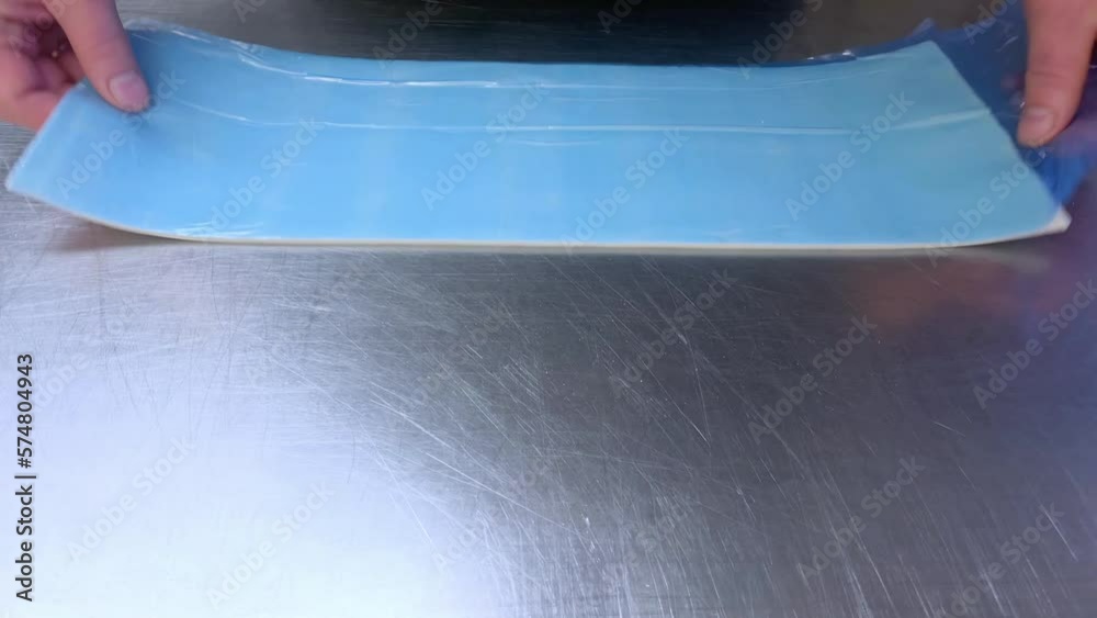 Men's Hands are making a Sausage Roll on a metal table. Top view of the ...