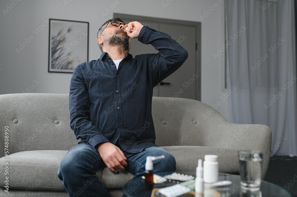 Foto de Portrait of man with a nasal spray. Sick man using nose drops ...