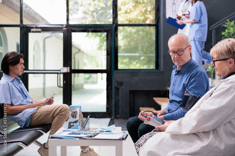 Elderly physician medic using tonometer instrument to measure patient ...