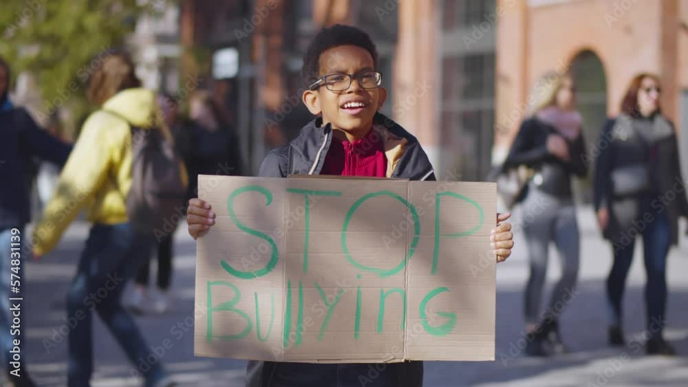African American teen boy with poster calling to stop bullying outside ...