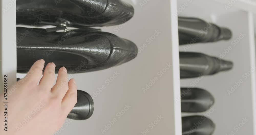 Woman decides which shoes to put on, vertical video. Close-up, a woman ...