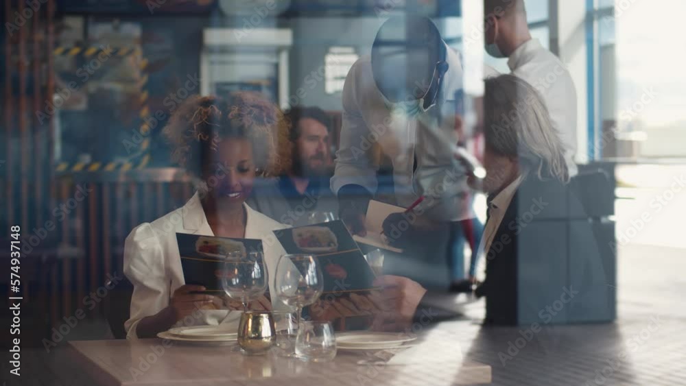 Waiter making recommendation for diverse couple in a restaurant ...