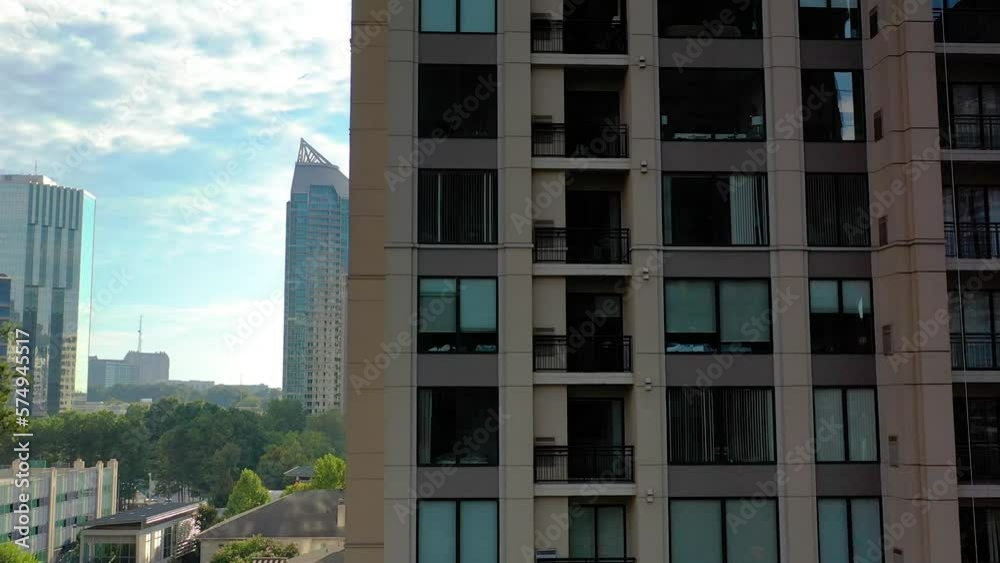 Slow moving drone shot flying from behind a skyscraper revealing ...