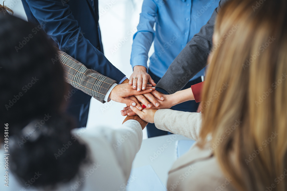 Foto de Top view of creative professionals putting their hands together ...