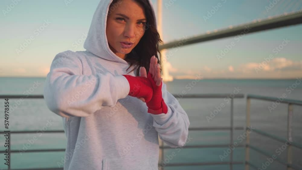 Female boxer in fighting stance staring into the frame, looking in ...