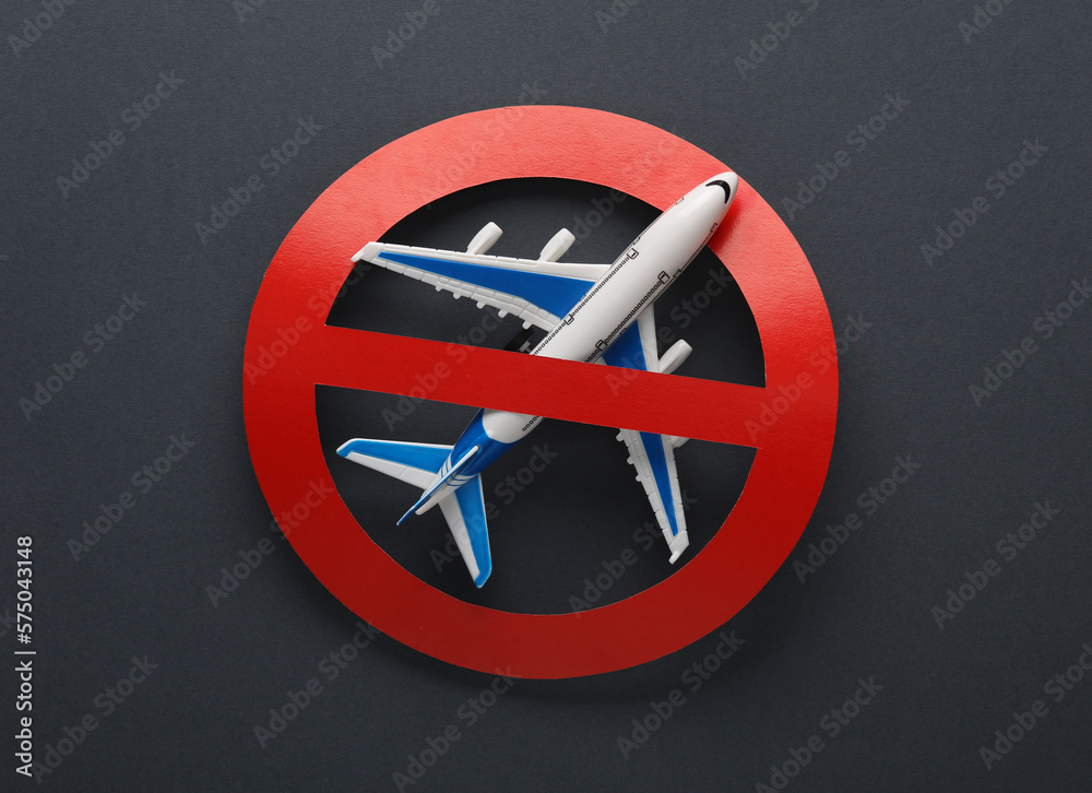 Flight ban. Model of passenger plane with prohibition sign on gray ...