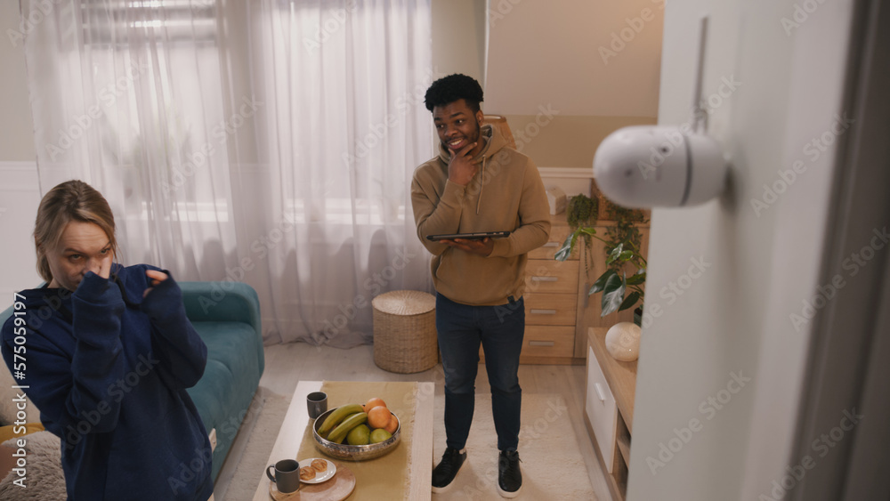 Multi ethnic couple install and set up security camera. Woman moves to ...