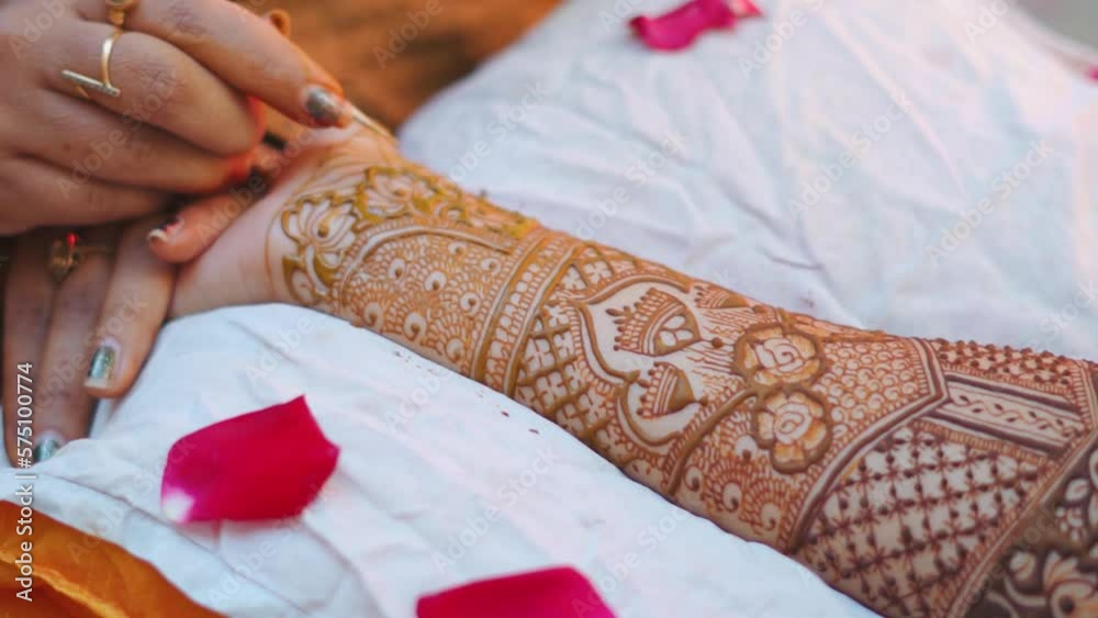 Close up shot of Mehndi artist drawing beautiful mehndi in Indian bride ...