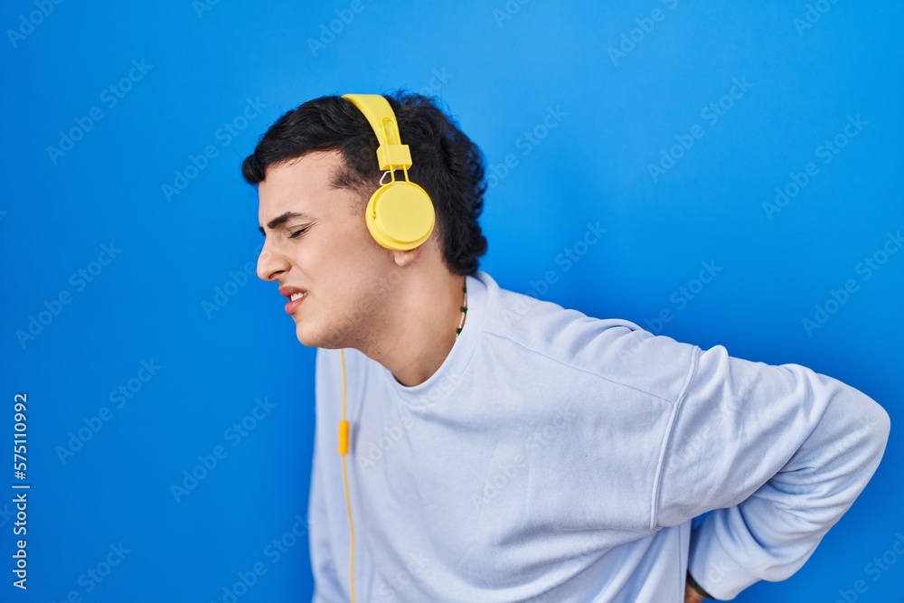 Non binary person listening to music using headphones suffering of ...