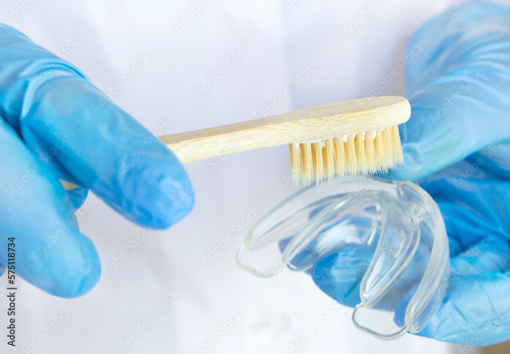 Dentist inserting retainers. Mouthguard with wooden toothbrush in ...