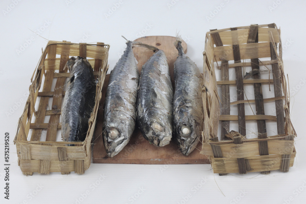 Pindang fish (salted fish) in a bamboo container and on a wooden ...