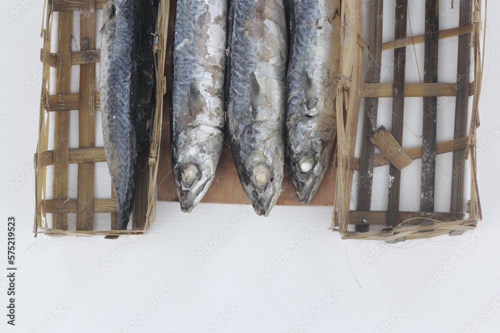 Pindang fish (salted fish) in a bamboo container and on a wooden ...