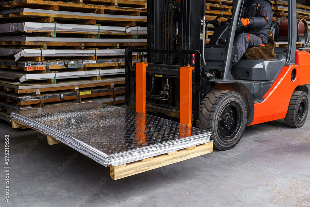 Forklift loader in the metal warehouse. Loading and unloading stainless ...
