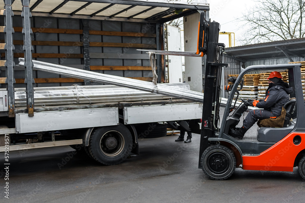 Forklift loader in the metal warehouse. Loading and unloading stainless ...
