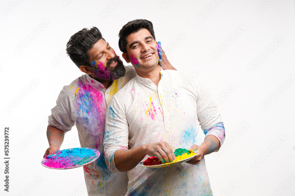 Two indian man applying color to each other and celebrating holi ...